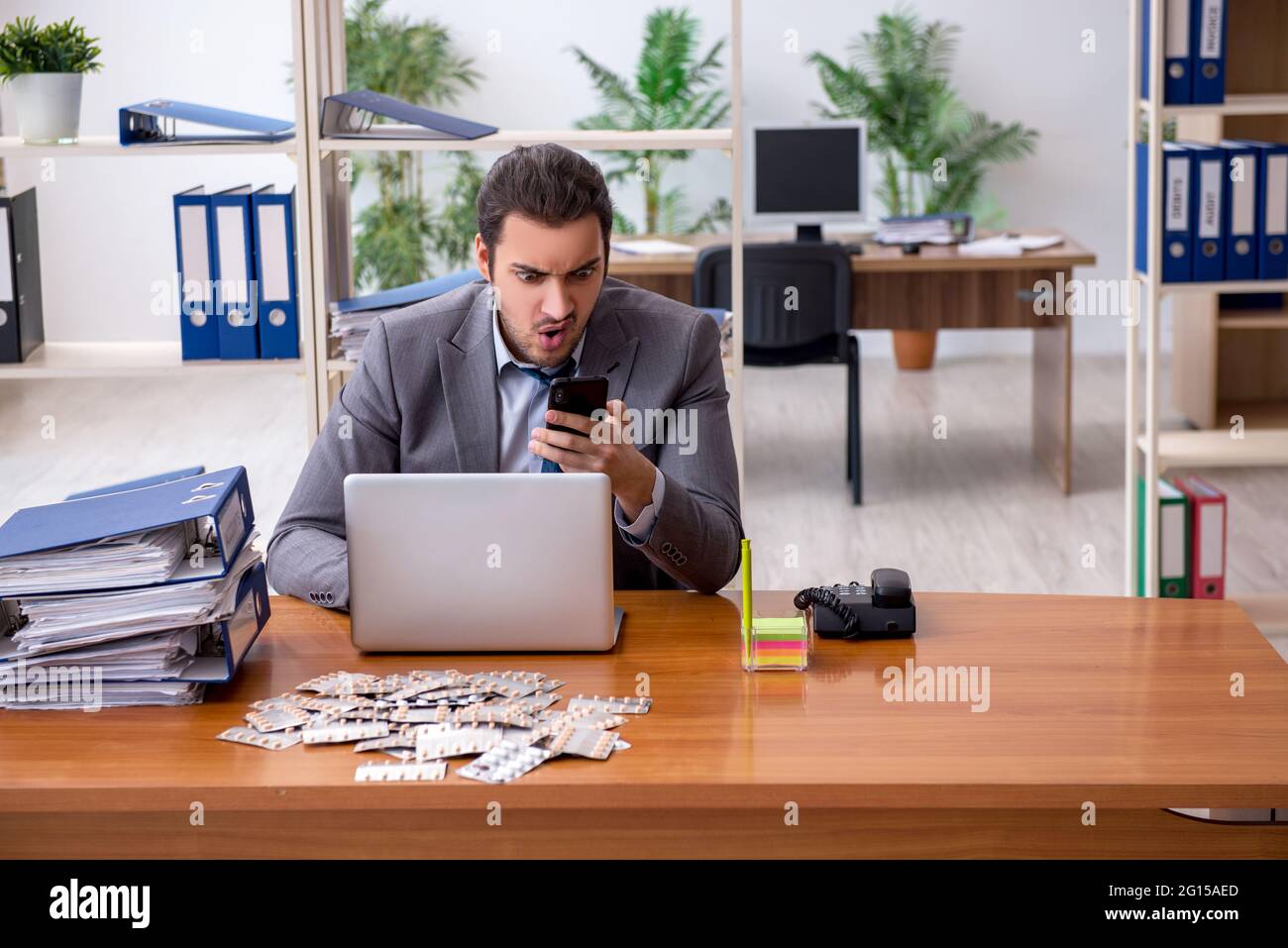 Male sick employee suffering at workplace Stock Photo - Alamy