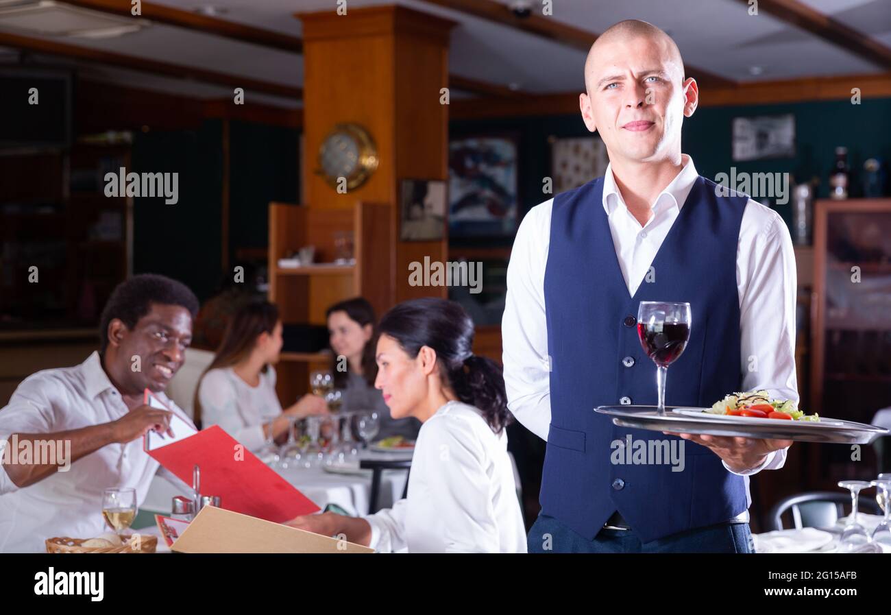 portrait of adult happy male garson standing in cafe Stock Photo - Alamy