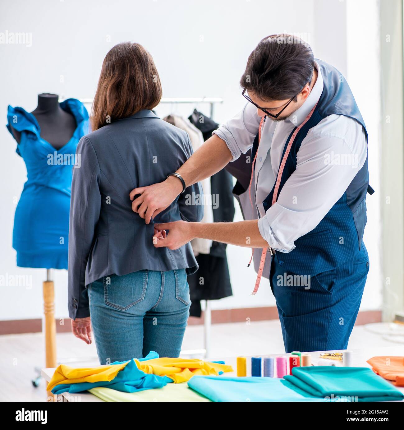 The professional tailor taking measurements for formal suit Stock Photo ...
