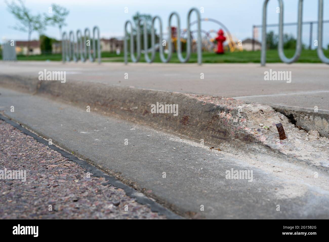 Broken sidewalk curb with exposed rebar and jagged edges that could ...