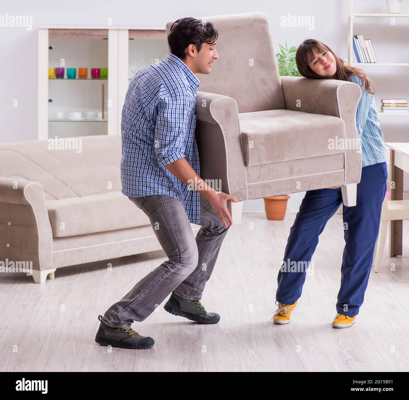 The man moving armchair in the living room Stock Photo - Alamy