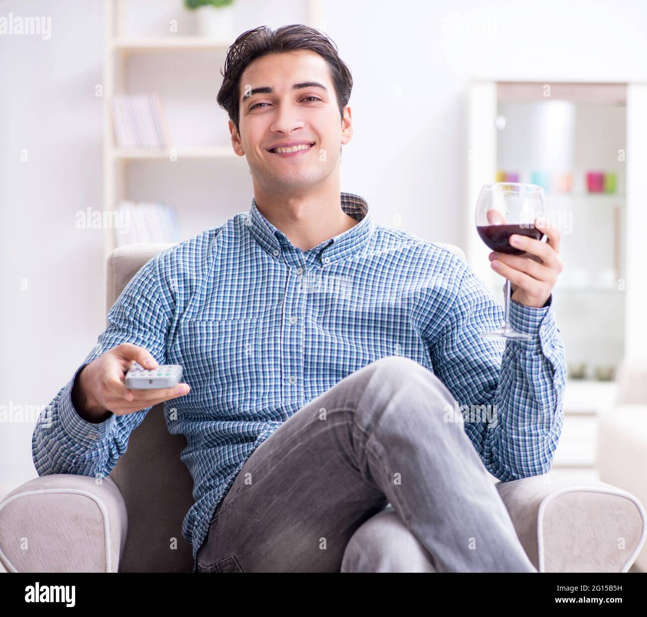 The young man drinking wine at home Stock Photo - Alamy