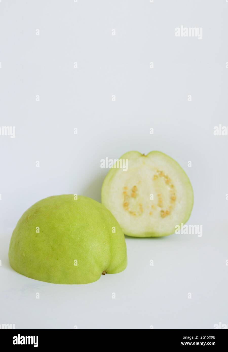 Green apple guava cut in half, up and down side on white background ...