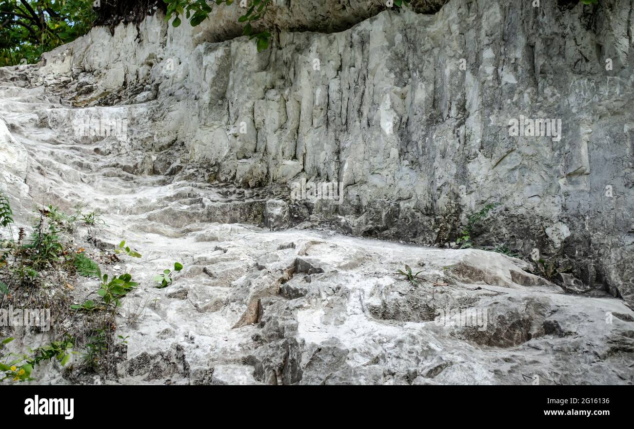 A trail in a chalk mountain with rocky ground and sheer rocky chalk ...