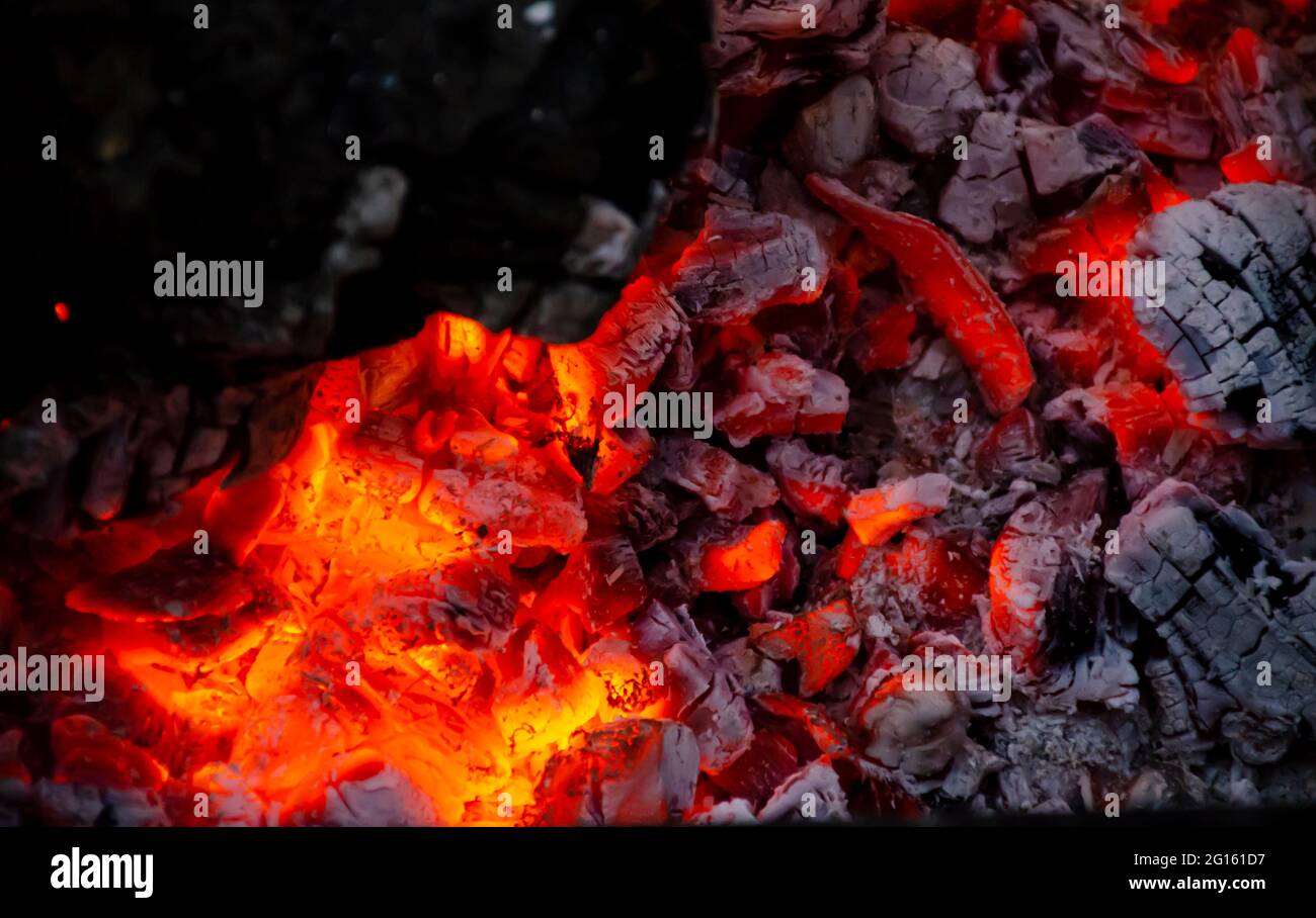 Burning log of wood close-up as abstract background. The hot embers of ...