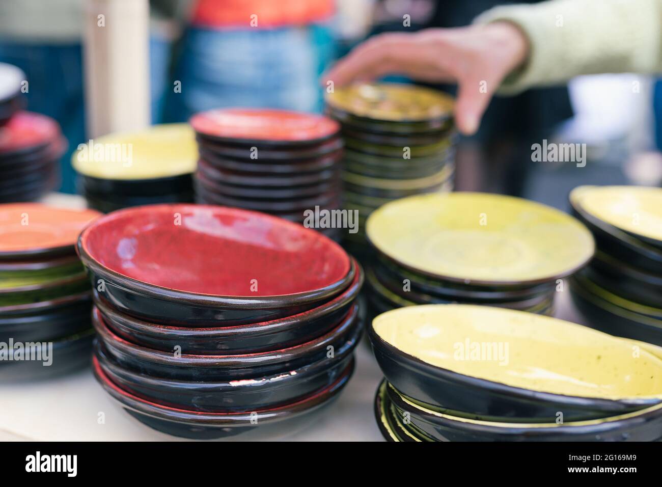 High stack of ceramic plates of different sizes, textures and colors.At ...