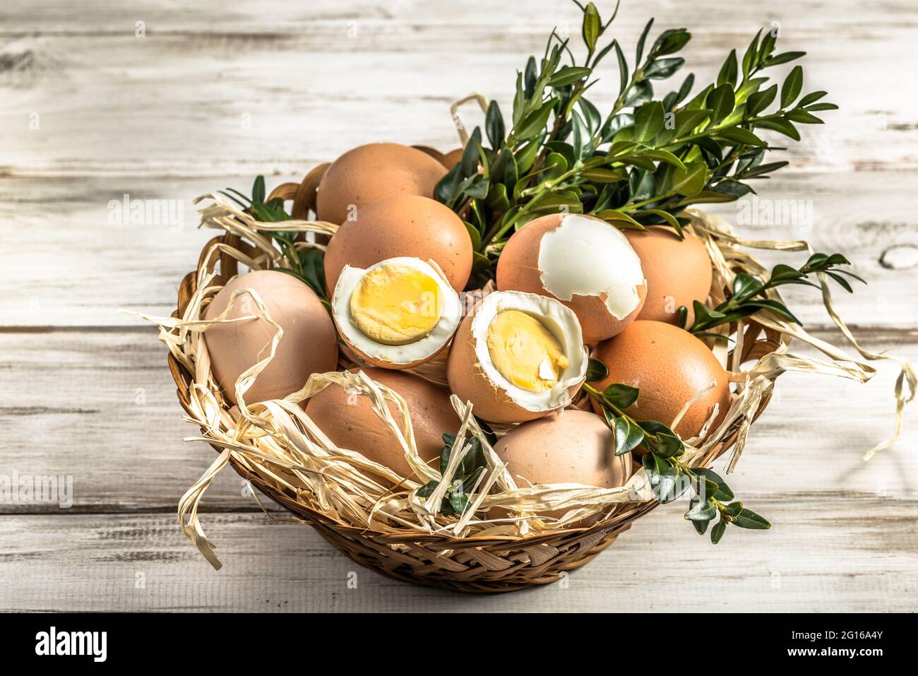 Fresh farm eggs in the basket and hard boiled egg isolated on white ...