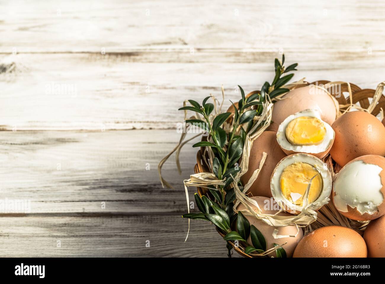 Fresh farm eggs in the basket and hard boiled egg isolated on white ...
