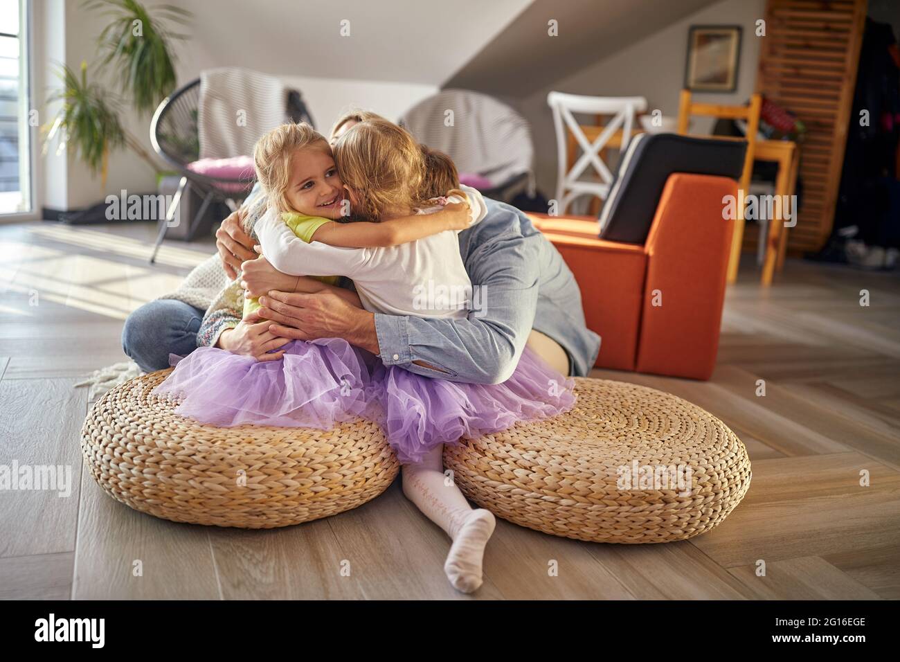 A young happy family enjoying a hug while playing in a cheerful ...