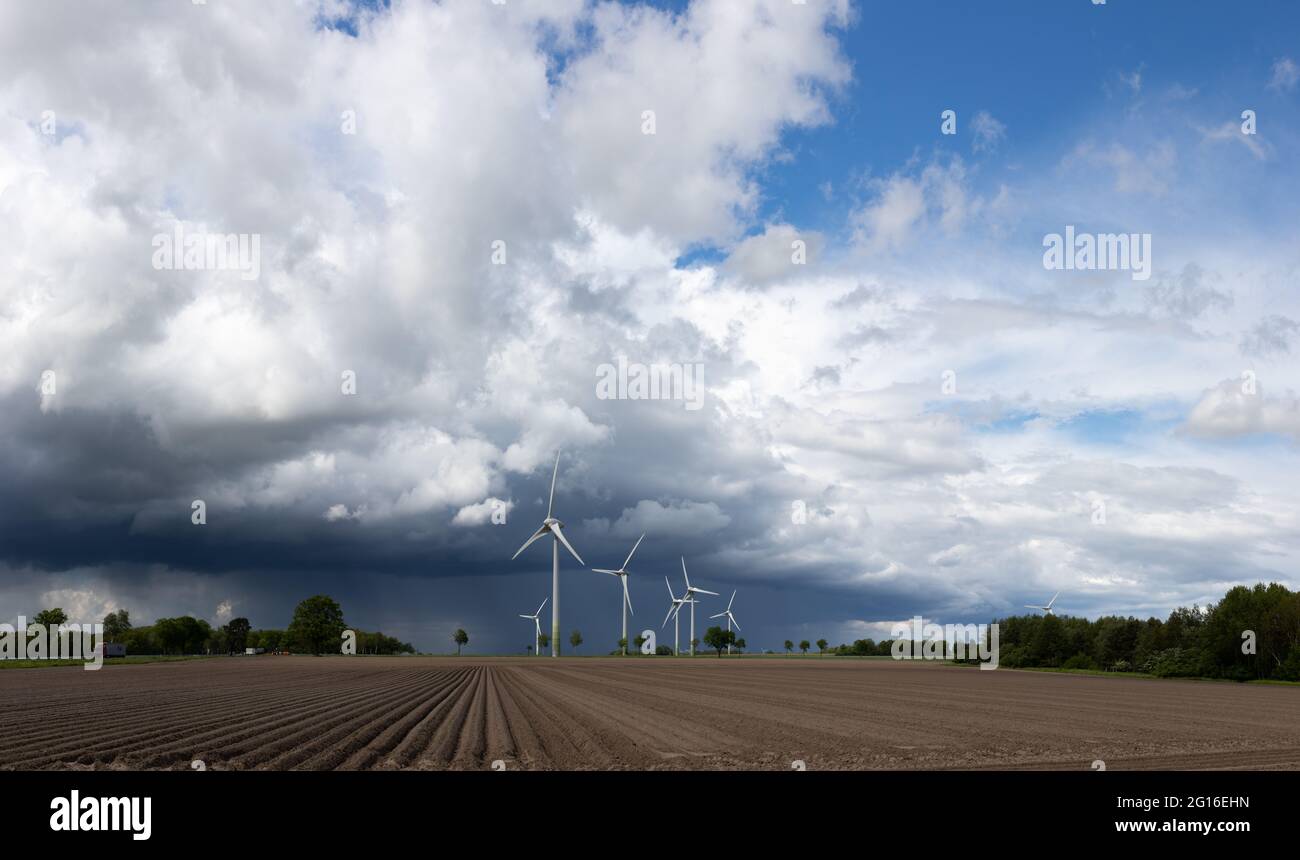 field with no crops in front of a wind farm producing clean energy and ...