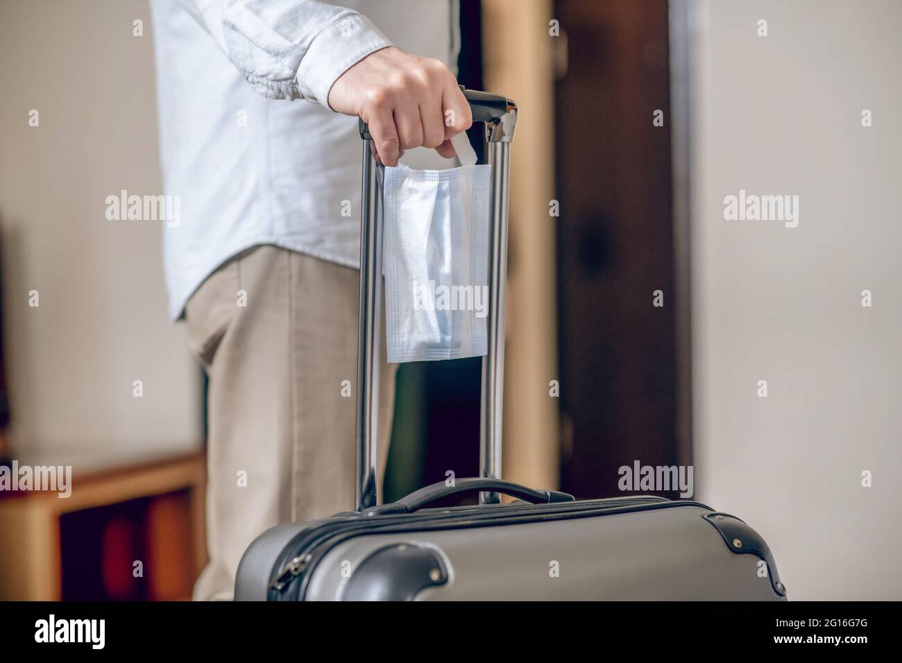 Close up picture of a mans hand holding a suitcase Stock Photo - Alamy