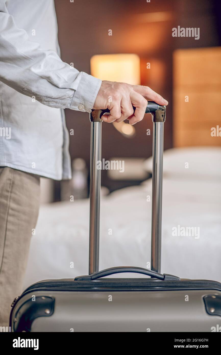 Close up picture of a mans hand holding a suitcase Stock Photo - Alamy
