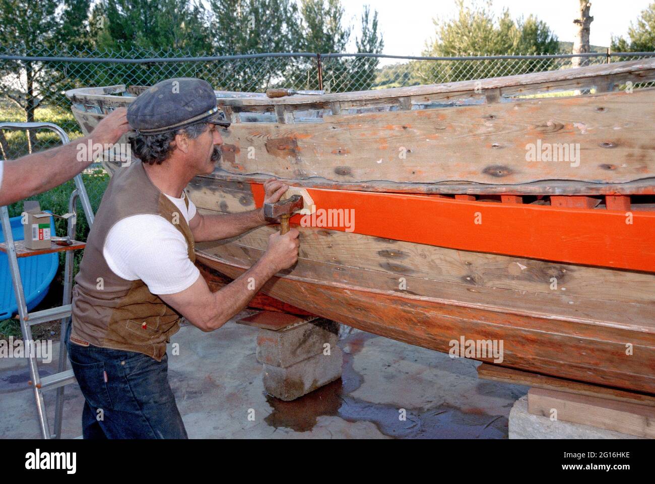 Shipwright repairing a wooden fishing boat Stock Photo - Alamy