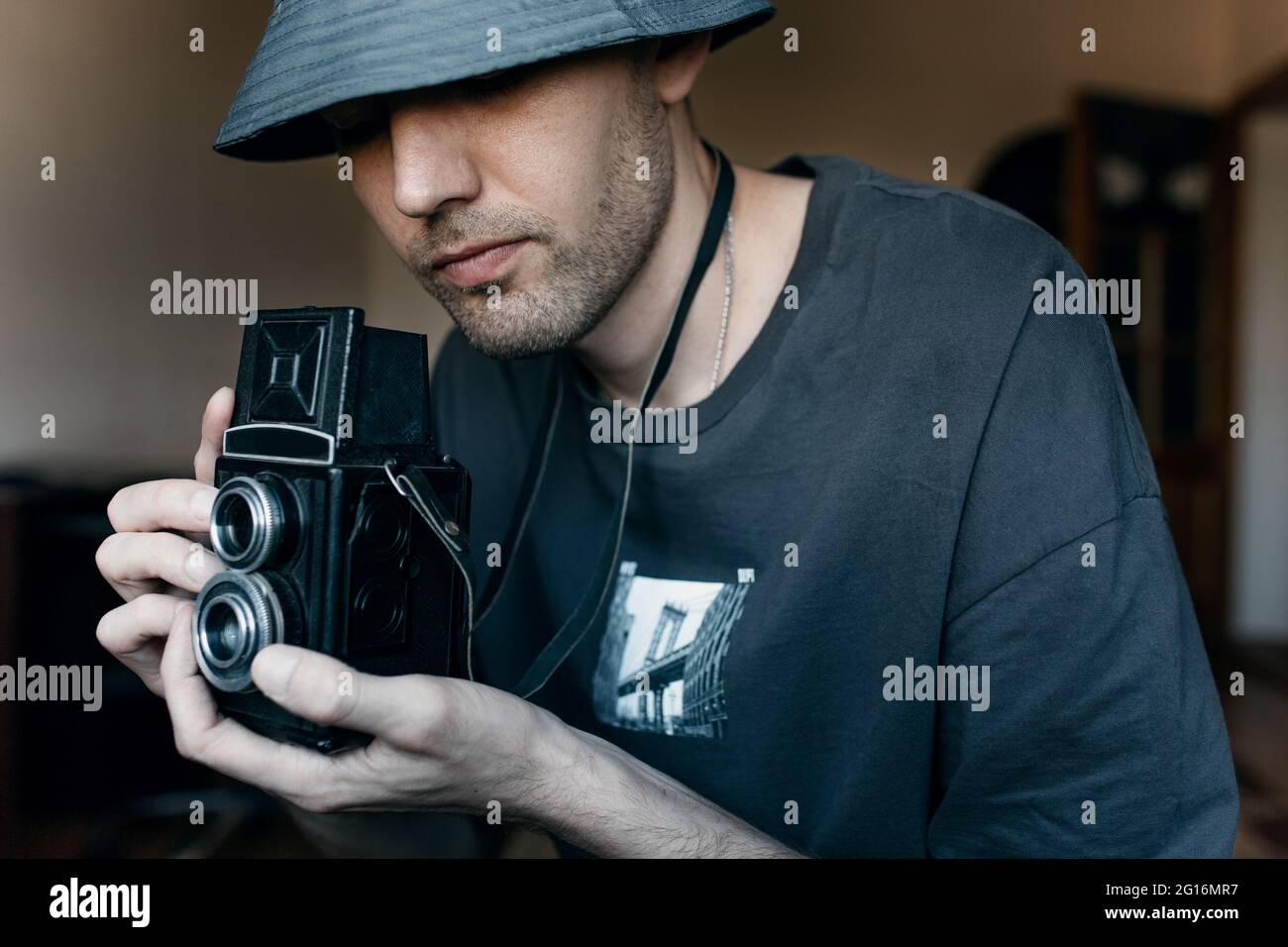 Guy with retro camera in hand takes pictures Stock Photo - Alamy