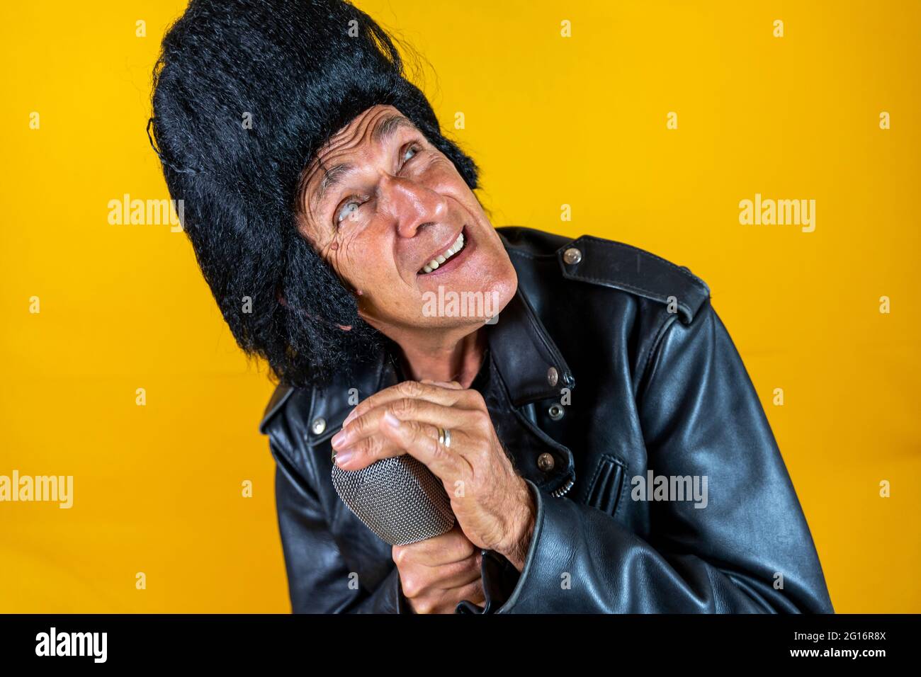 Funny portrait of mature rocker. An old singer dressed in rockabilly ...