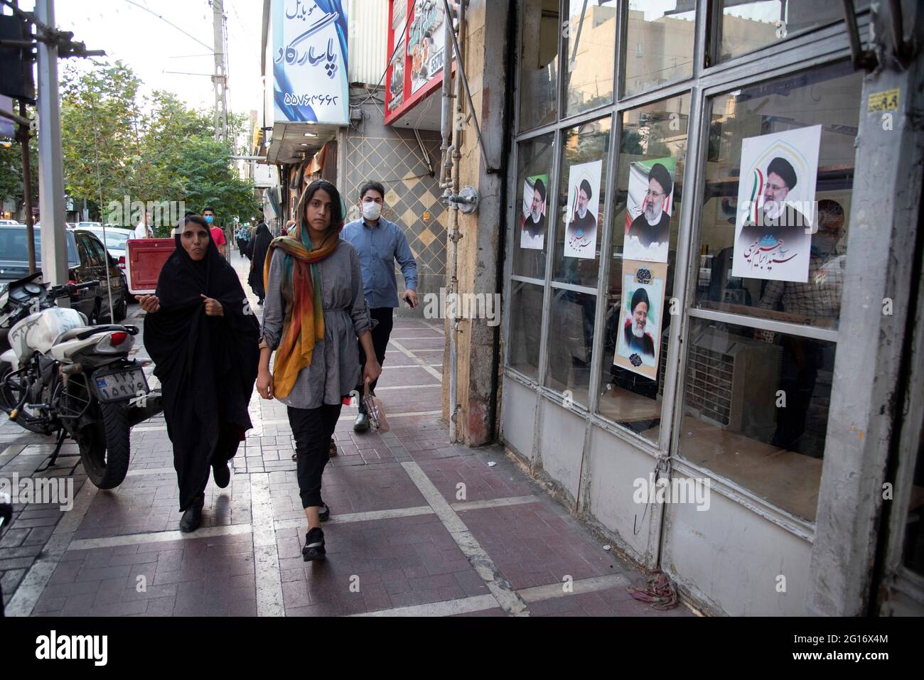 (6/4/2021) Two Iranian women walk past a campaign center for the ...