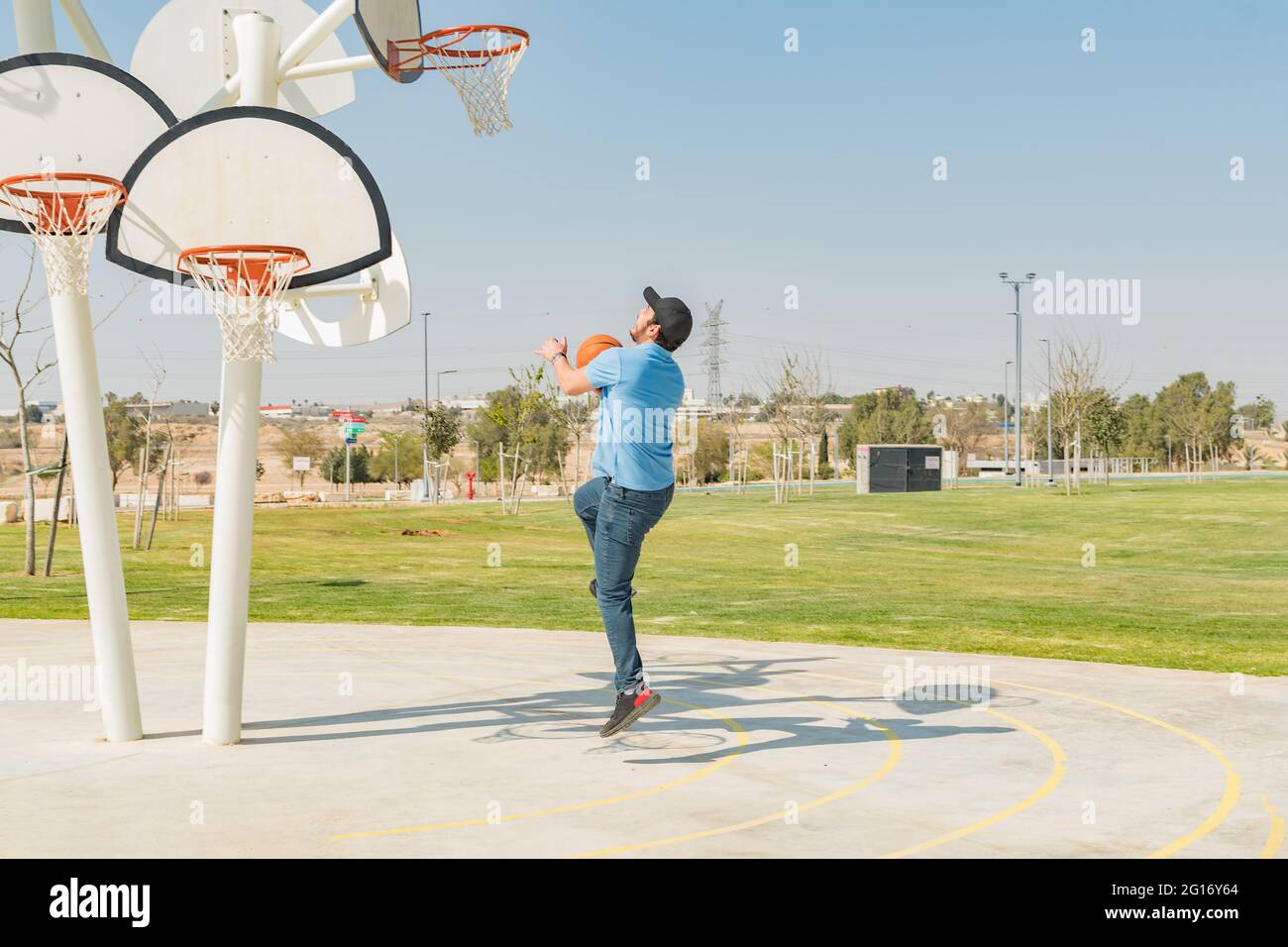 Side view of a young man playing basketball in sports park Stock Photo ...
