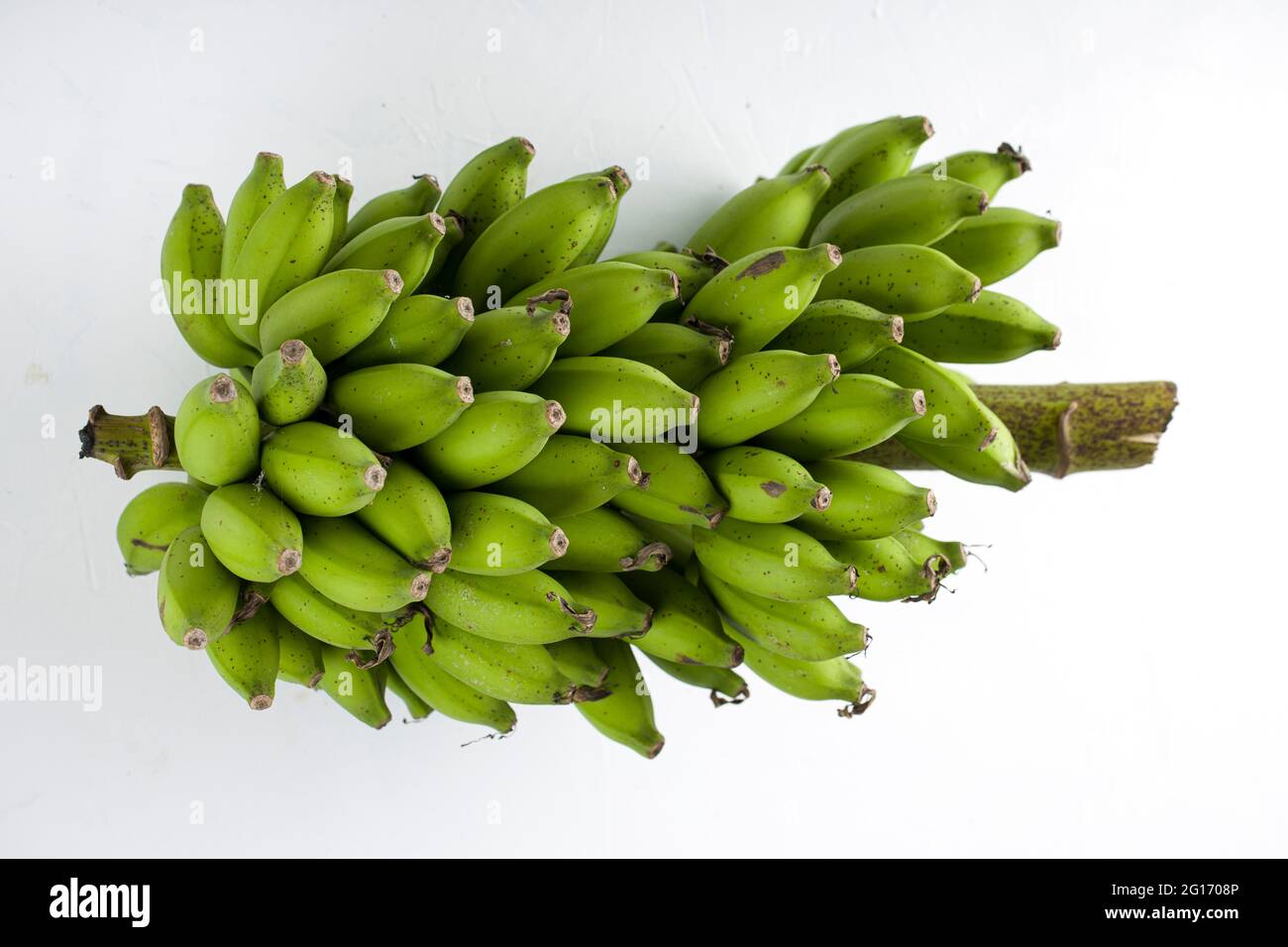Bunch of raw banana or green banana placed on a white surface with ...