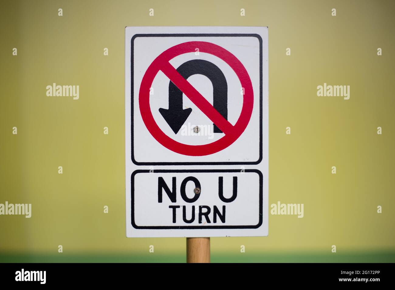 Closeup shot of a white "No U-turn" sign on a blurred background Stock ...