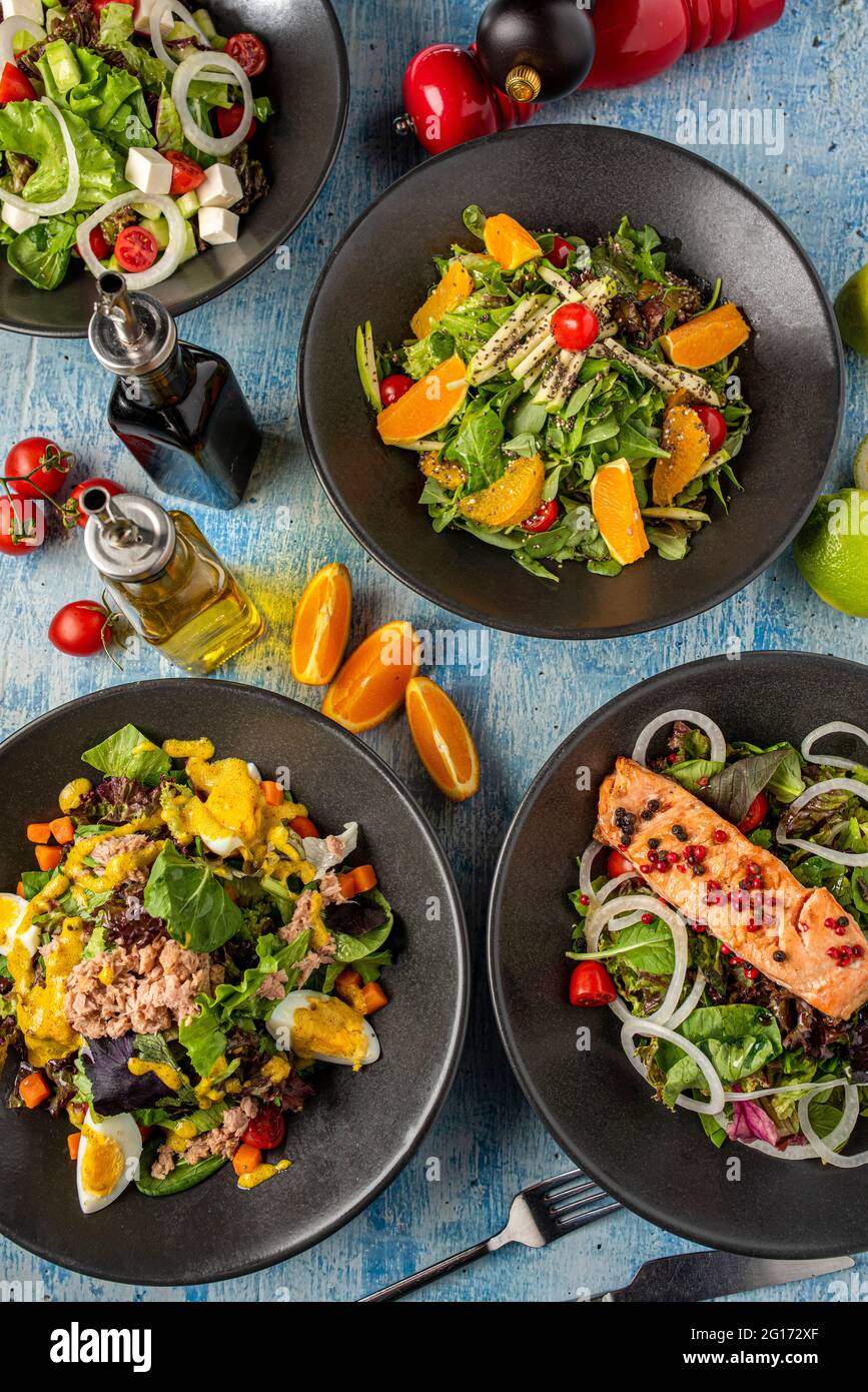 Four different types of salads served freshly on blue stone table Stock ...