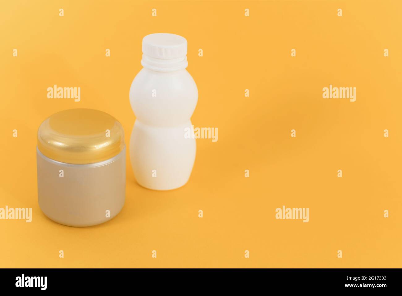 Mockups of two unbranded bottles for branding and labeling on orange ...