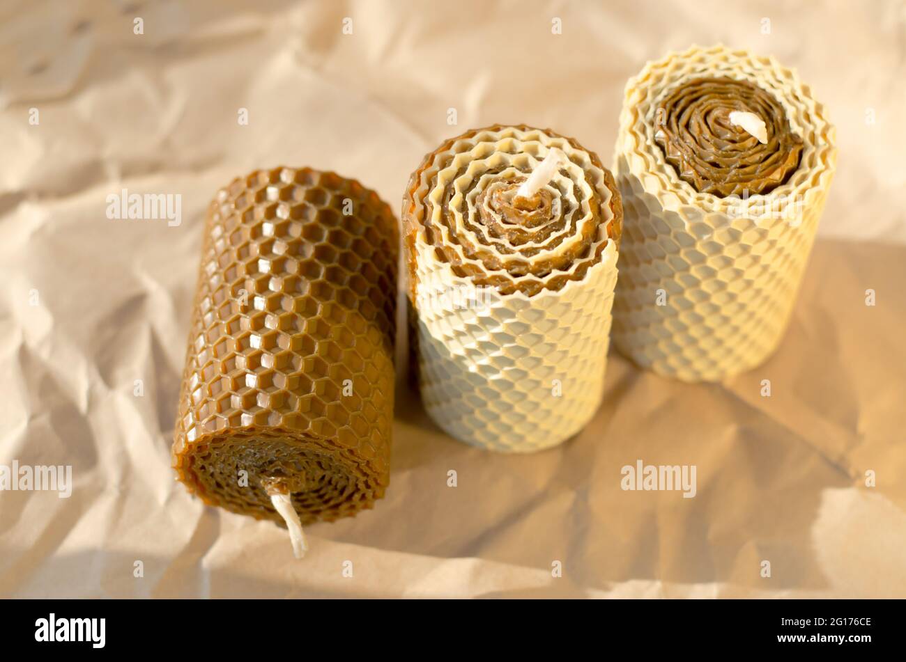 Handmade decorative wax candles on crumpled parchment paper. Candles in ...