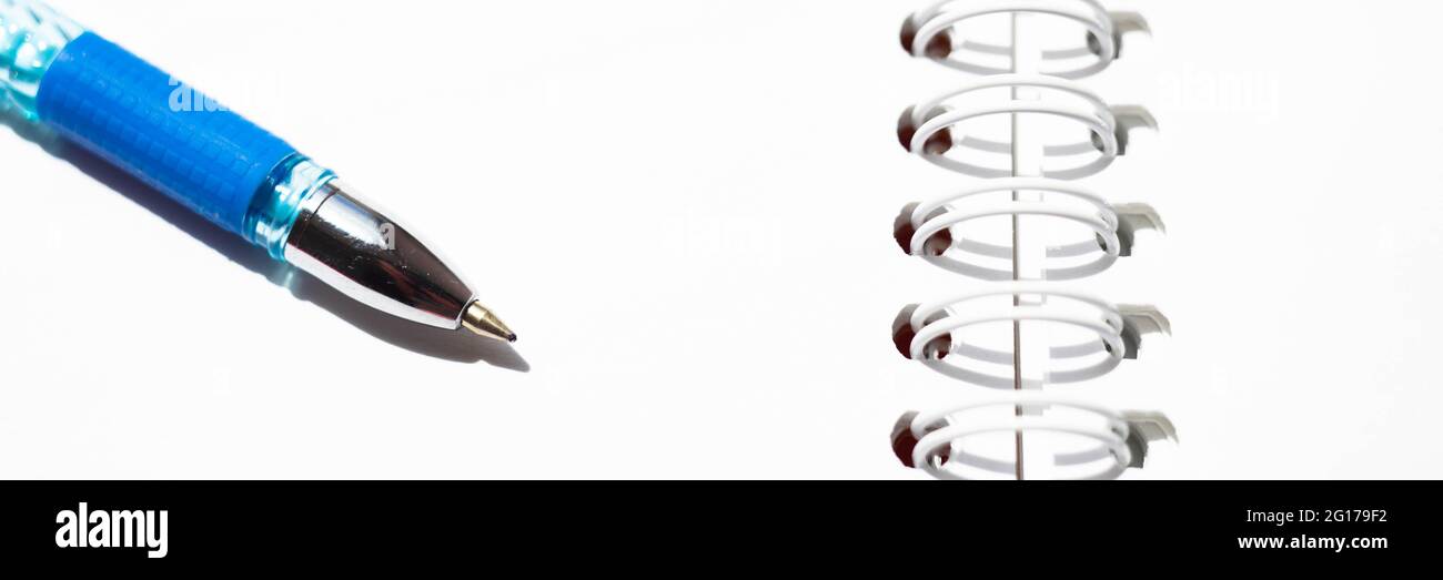 Blue ball pen on a bright sunny white notebook paper Stock Photo - Alamy