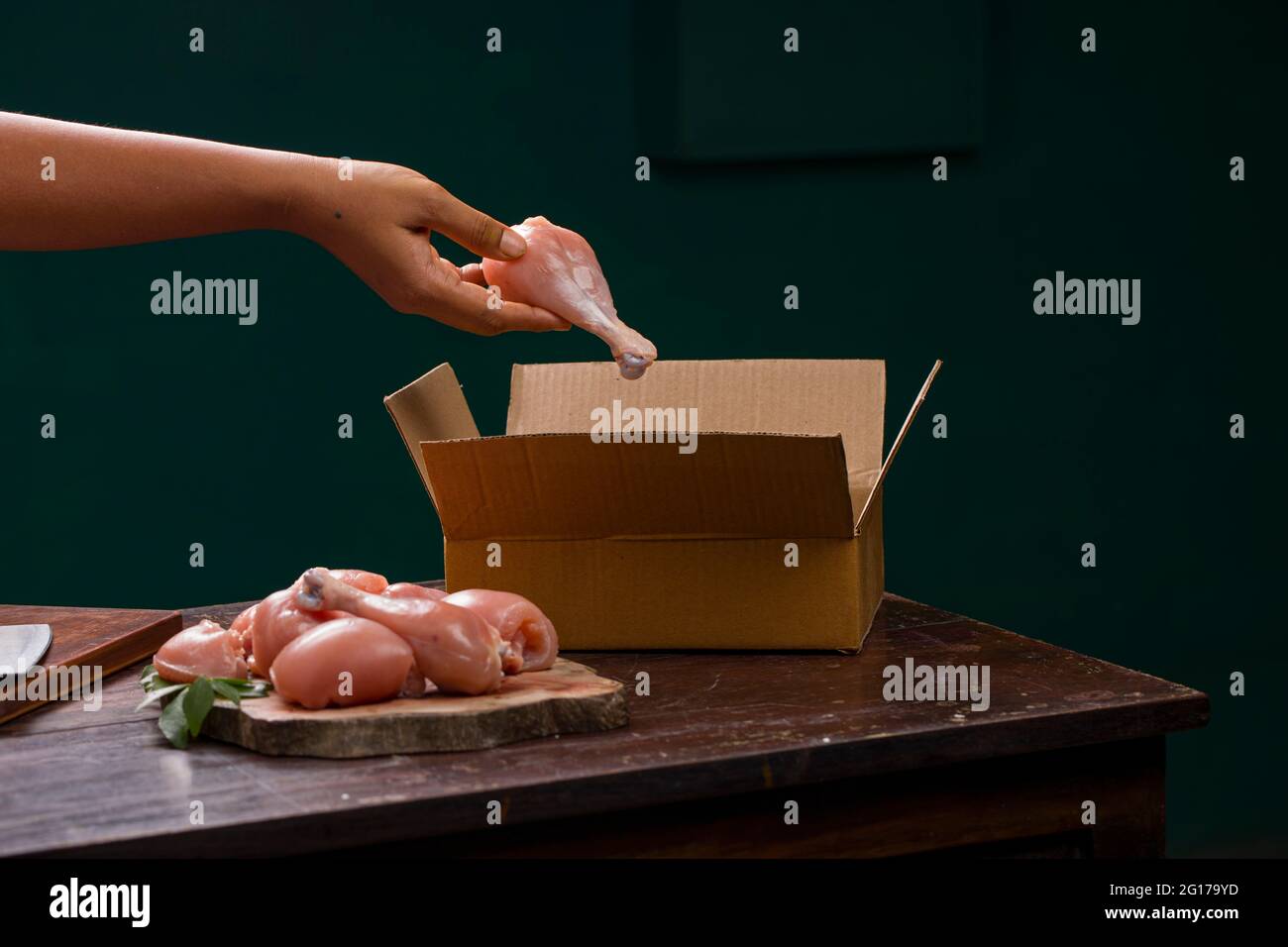 Raw chicken cuts or parts without skin arranged on a sliced wooden log ...