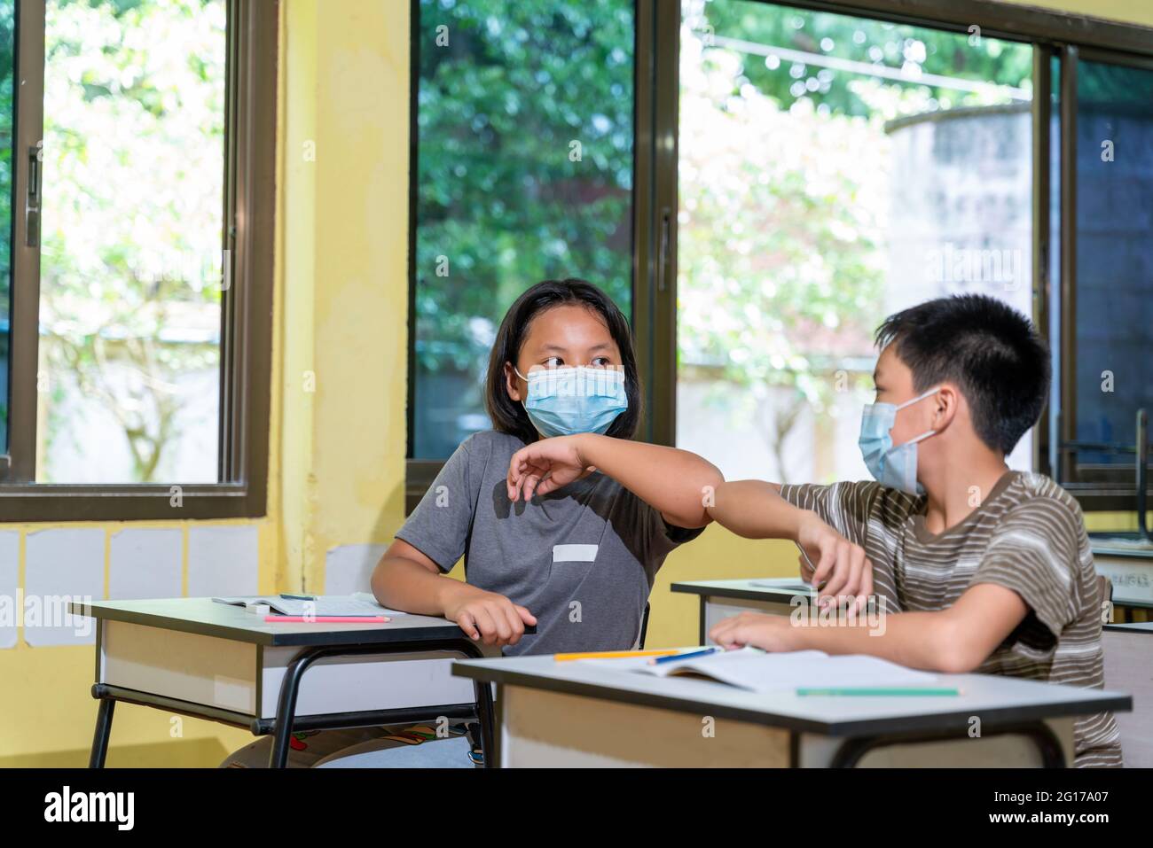 Asian children in classroom with face mask back at school after covid ...