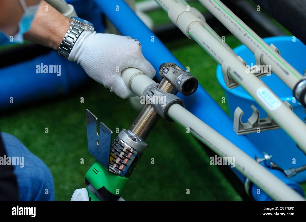 Plumber hands in gloves cut plastic pipes with the polyfusion welding ...