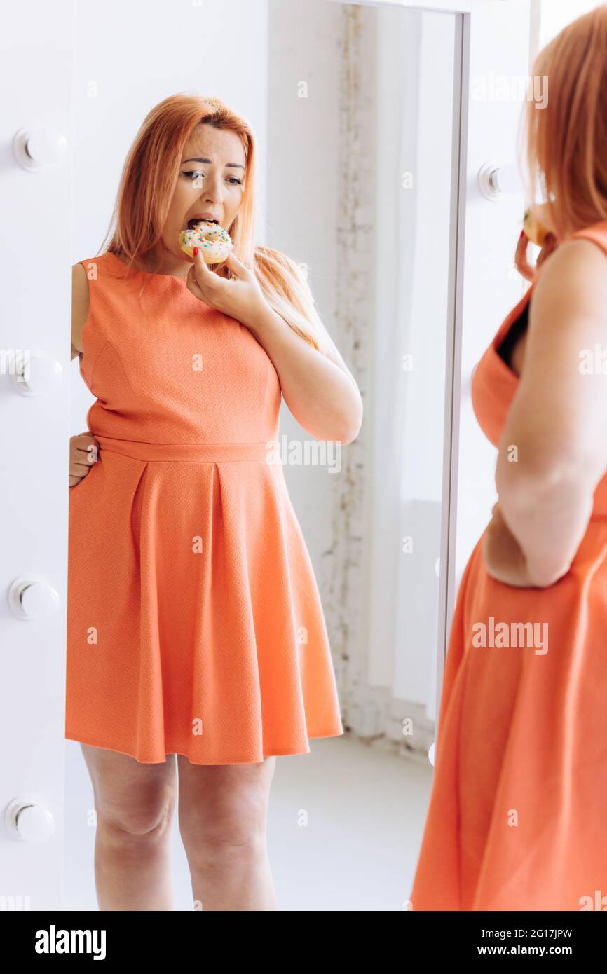 Overweight woman looking in mirror hi-res stock photography and images ...