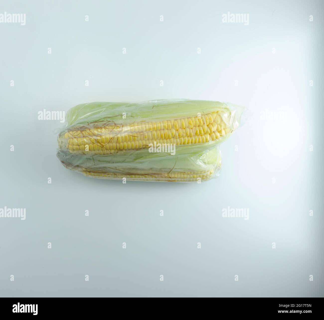 Fresh corn wrapped in transparent plastic Stock Photo - Alamy