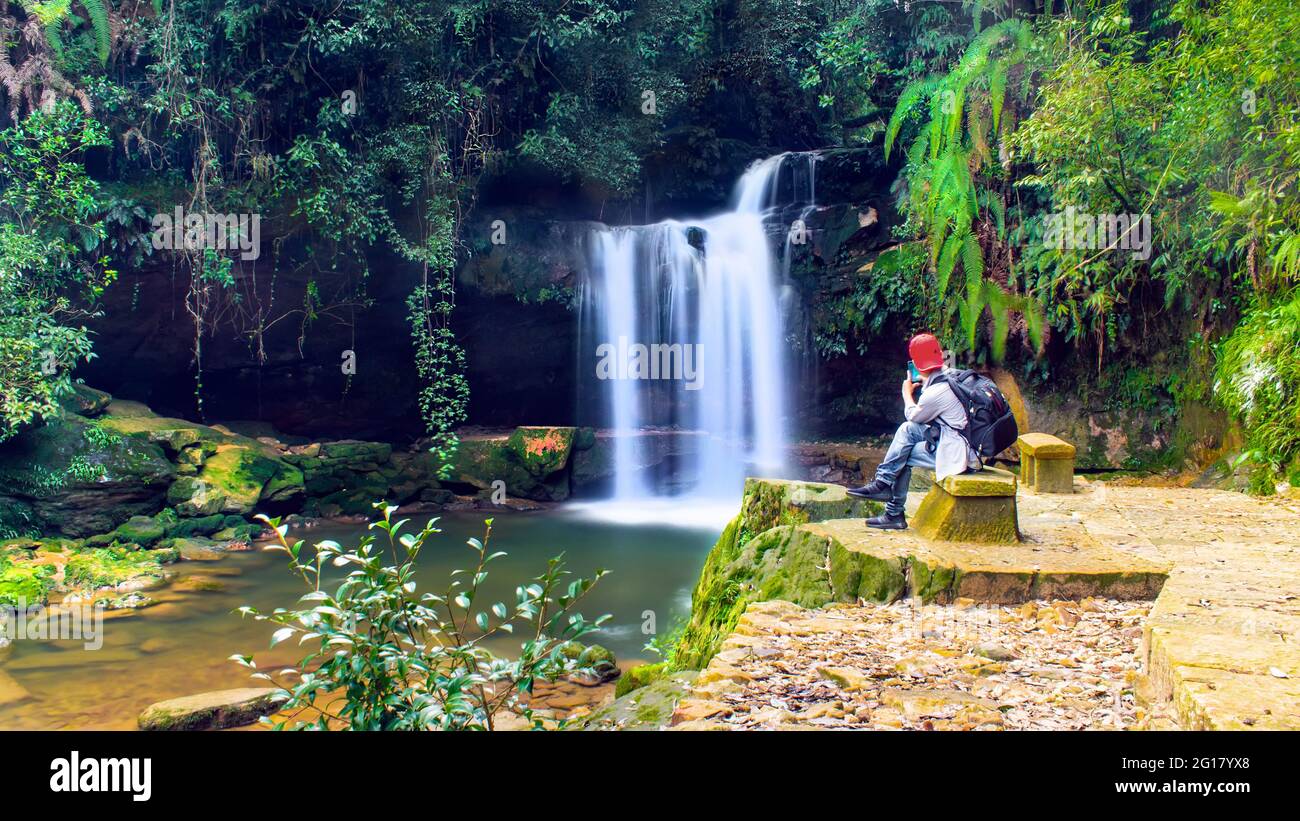 Tourist taking a mobile picture of a beautiful Asdad Waterfalls, in ...