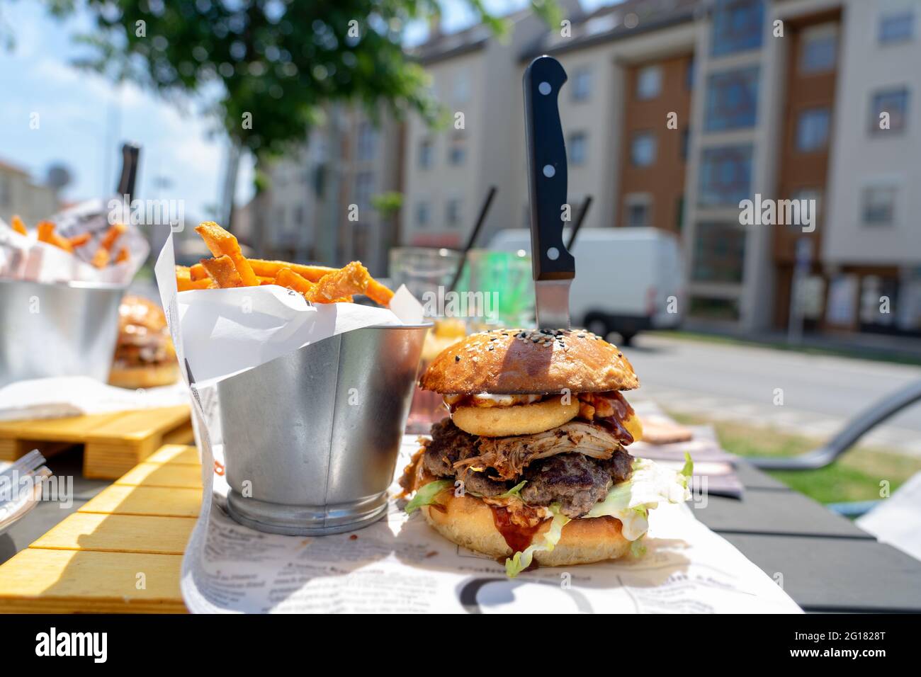 eating street food burger on the street with sweet potato fries Stock ...