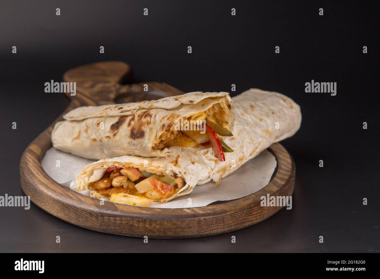 crispy chicken wrap fast food meat wood plate black back ground Stock ...