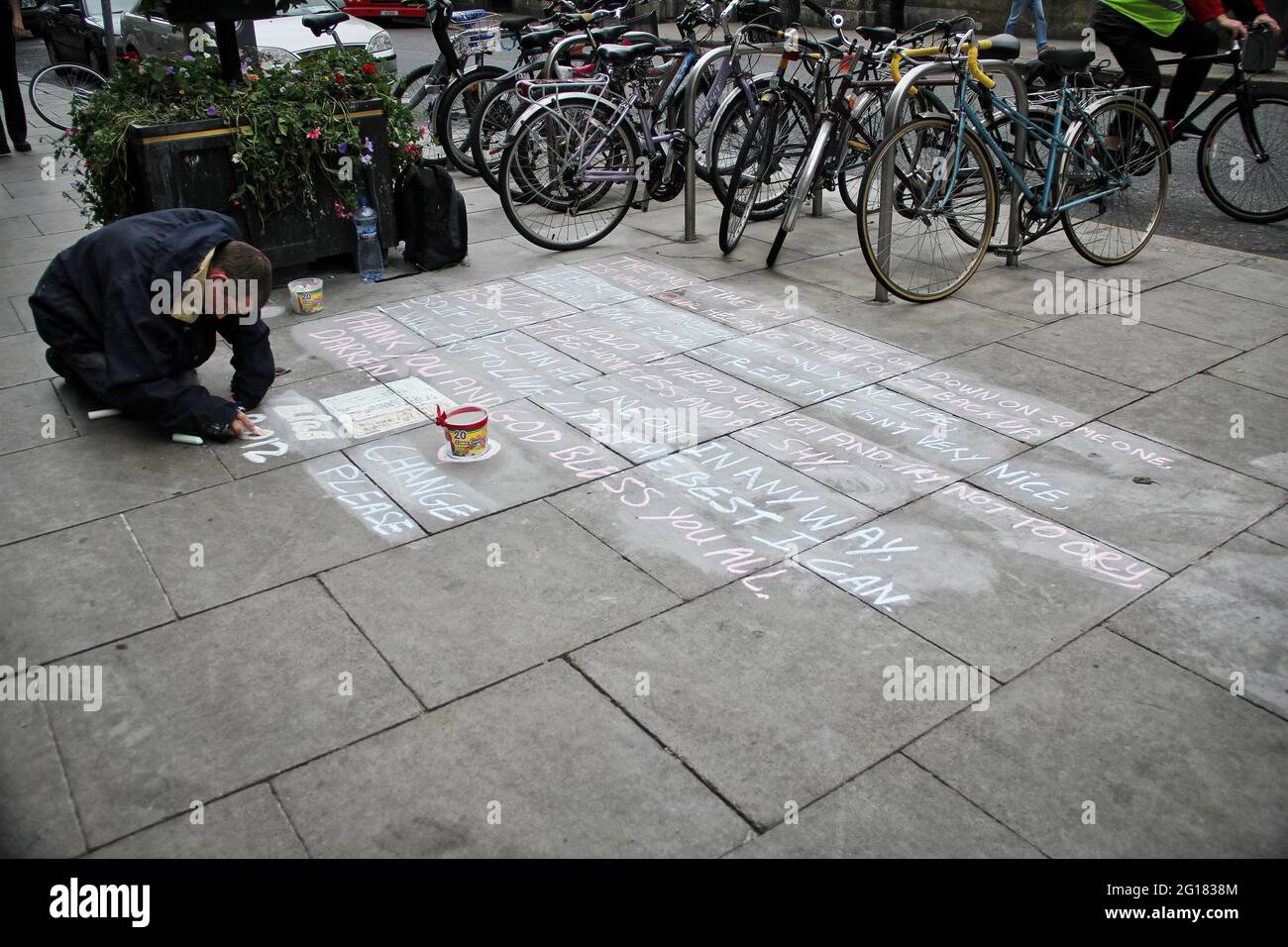 DUBLIN, IRELAND-- MAY 28, 2012: Homeless man writing a sad message on ...