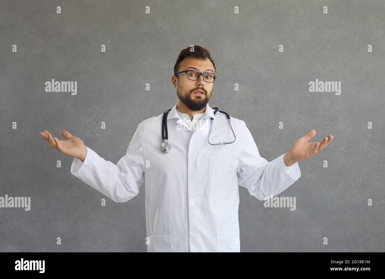Puzzled clueless adult male doctor with arms out, shrugging shoulder ...