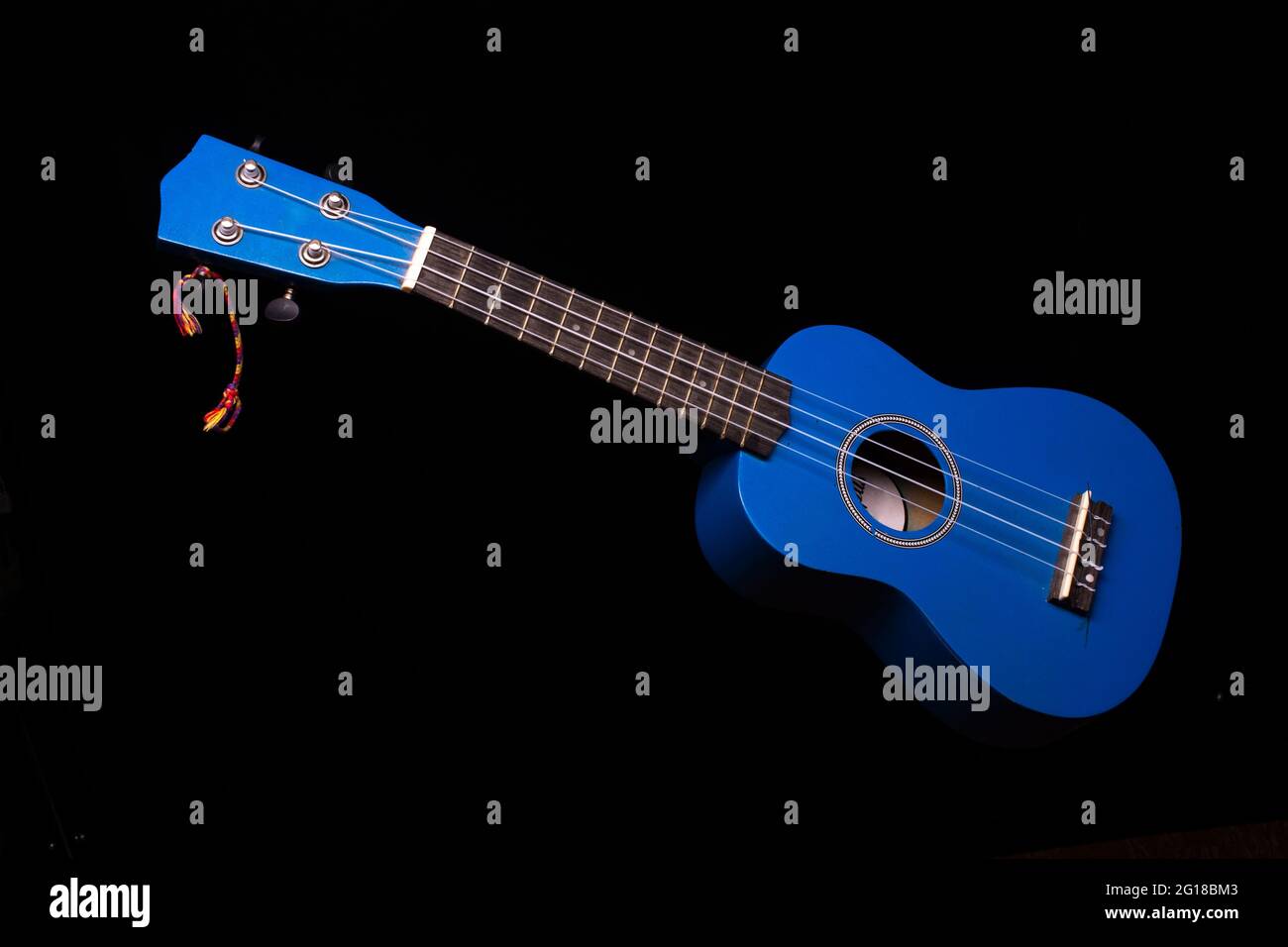 blue ukuleles on black background Stock Photo - Alamy