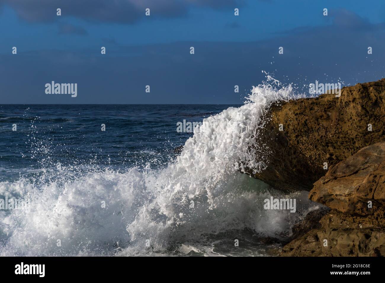 Wave breaking on rock in Laguna Beach, California. Water spilling over ...
