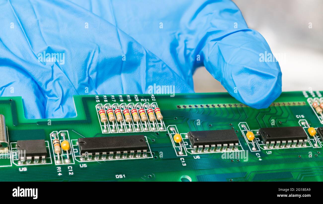 Electronic components on green printed circuit board on human hand ...