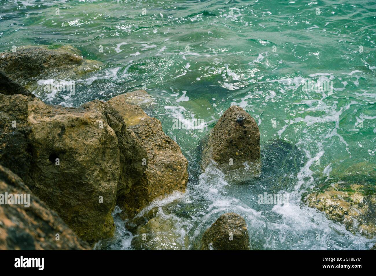 Stone beach of the sea. Top view of the waves and rocks. Close-up ...