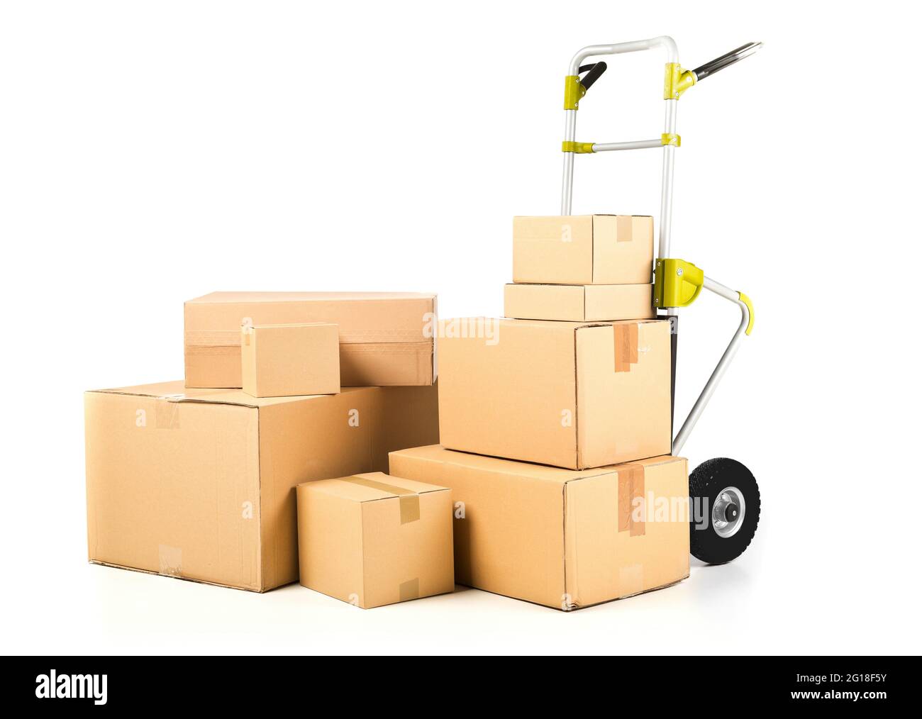 Heap or stack of brown carton transport boxes with barrow over white ...