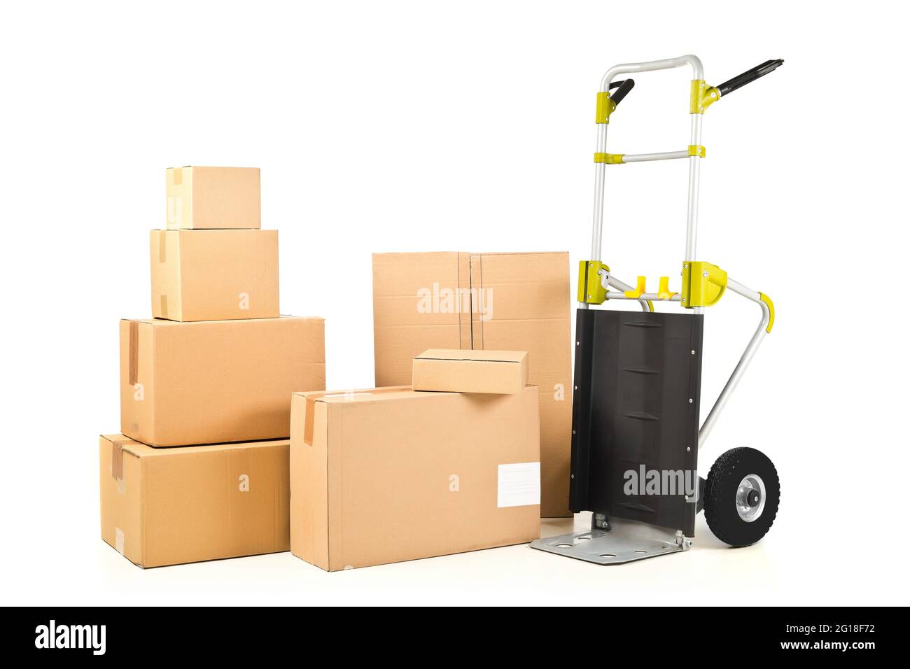 Heap or stack of brown carton transport boxes with barrow over white ...