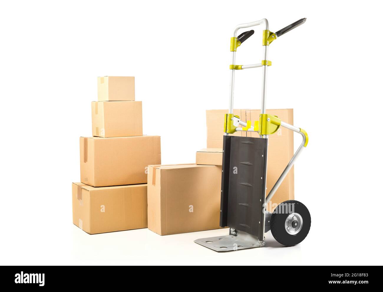 Heap or stack of brown carton transport boxes with barrow over white ...
