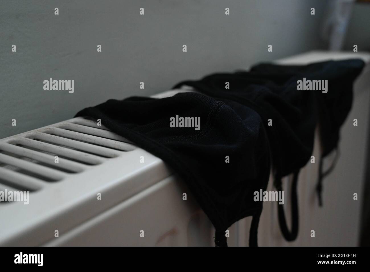 Reusable face masks dry at home on the radiator Stock Photo - Alamy