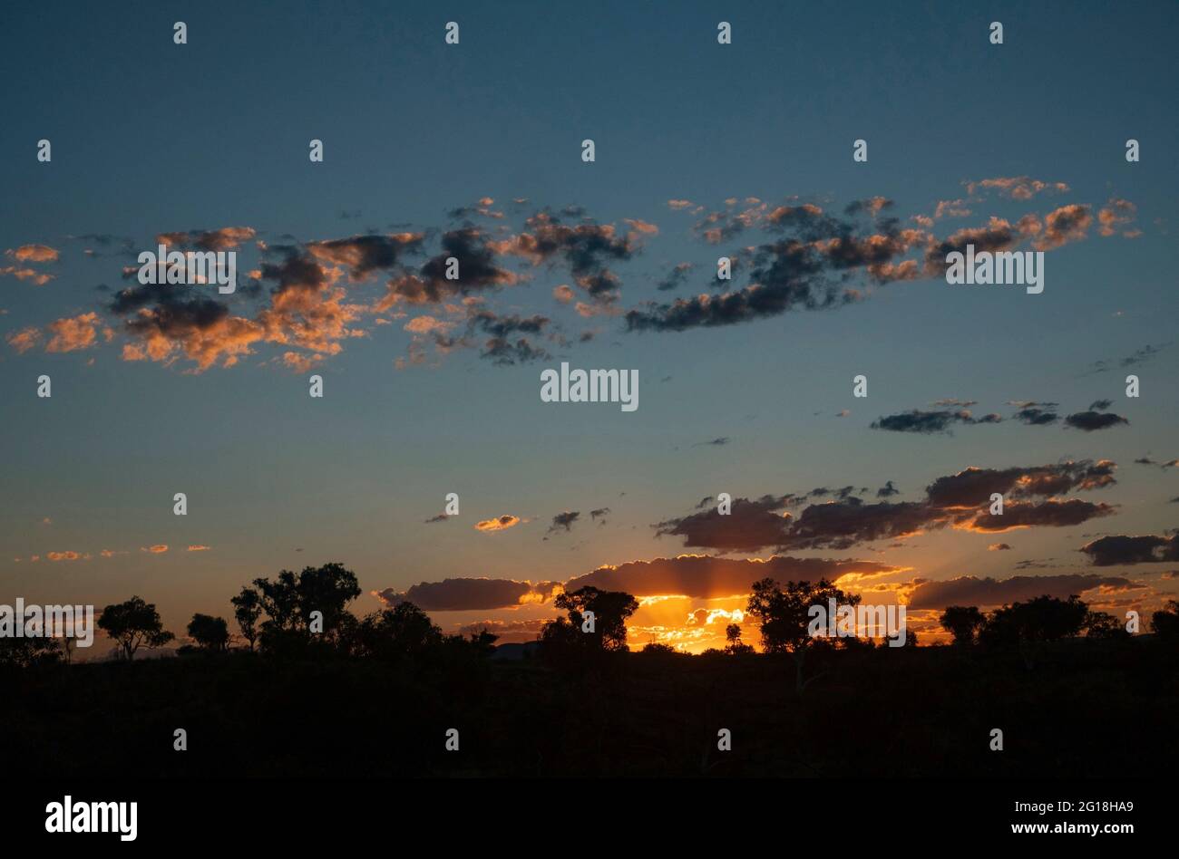 Sunset over outback Australia with blue sky, clouds, orange glow and ...