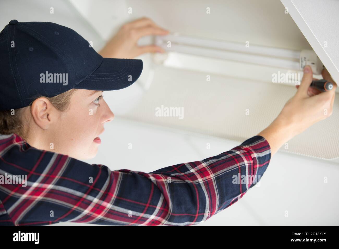 woman fixing broken lamp Stock Photo - Alamy
