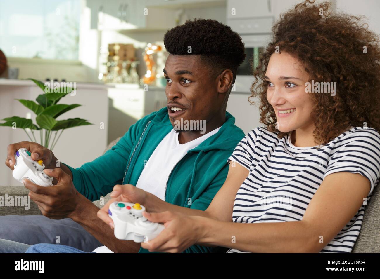 multiracial couple with joysticks playing video game Stock Photo - Alamy