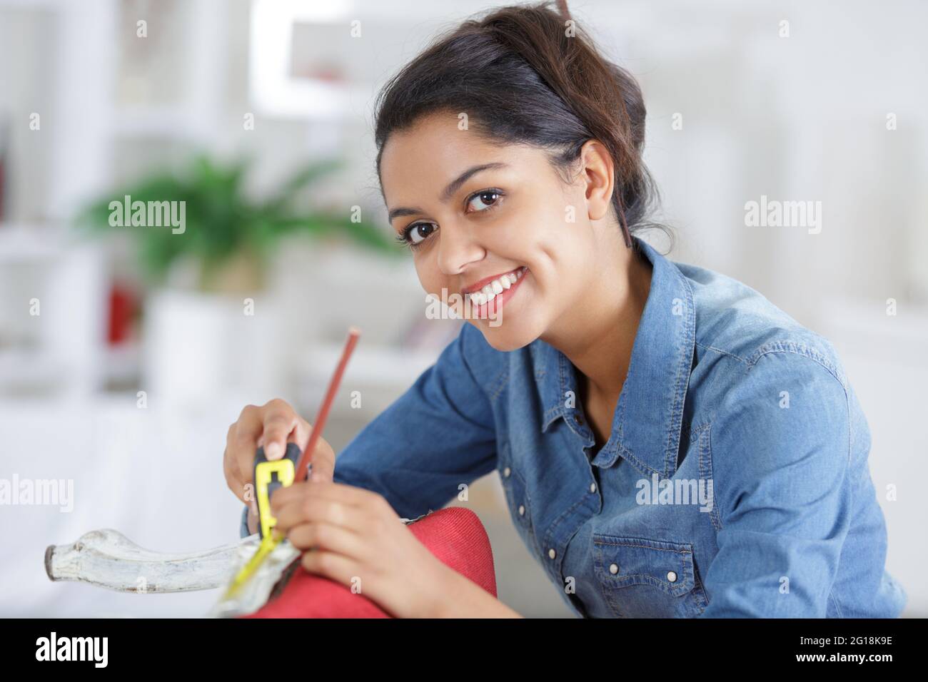 a young woman measuring chair Stock Photo - Alamy