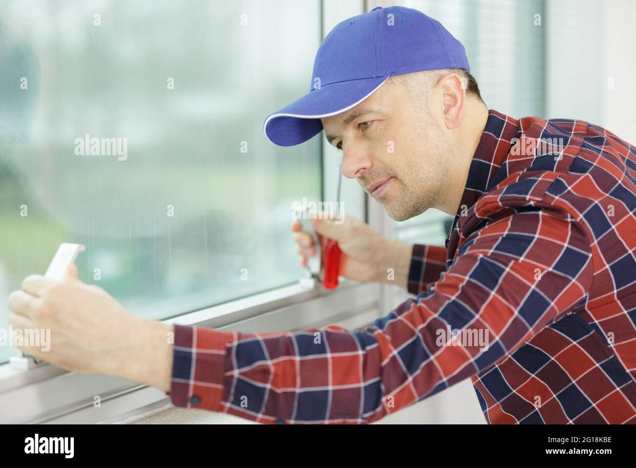 a repairman is fixing window Stock Photo - Alamy